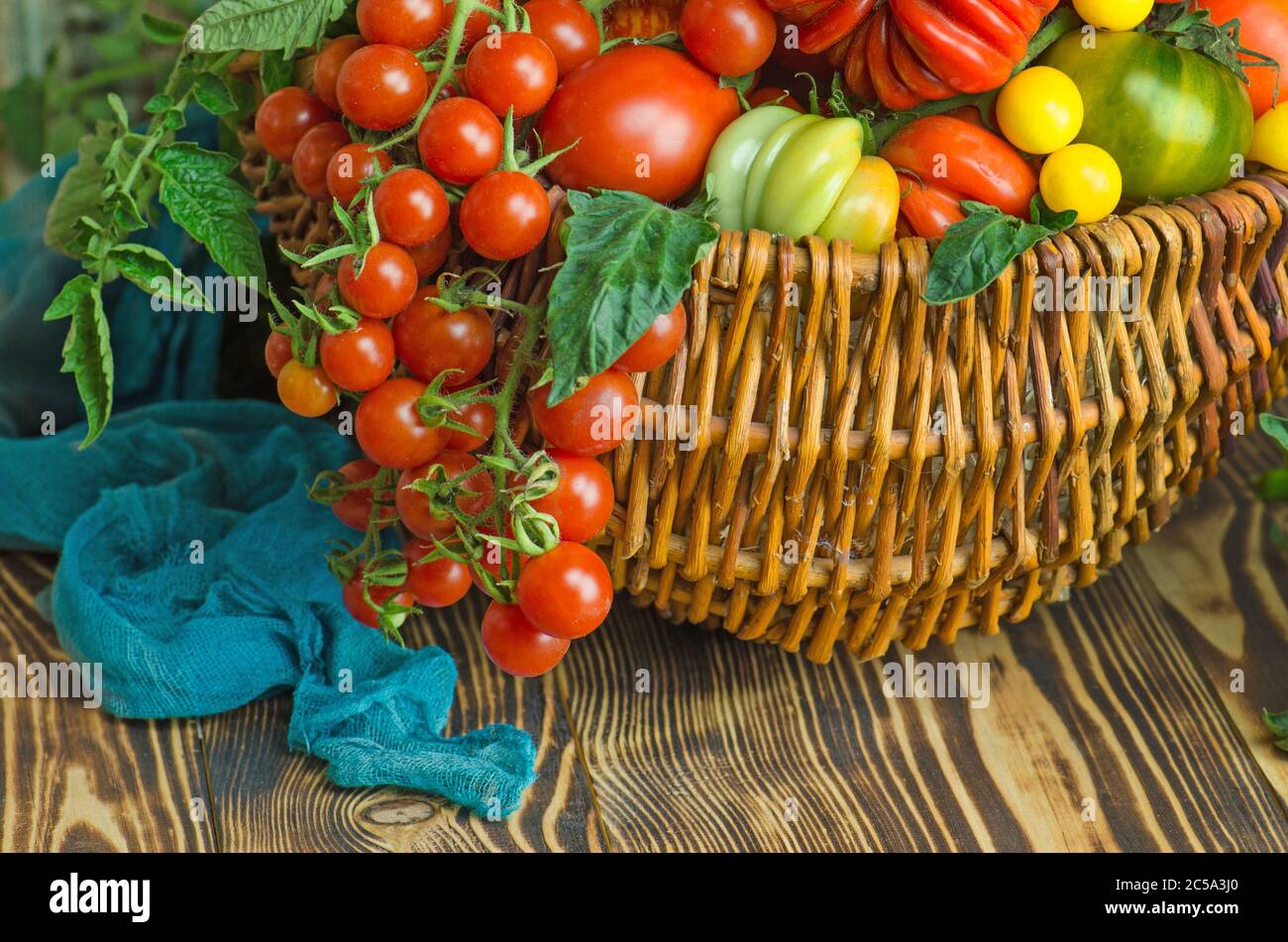 Fresh red tomatoes in basket in the kitchen. Tomatoes on a wooden ...