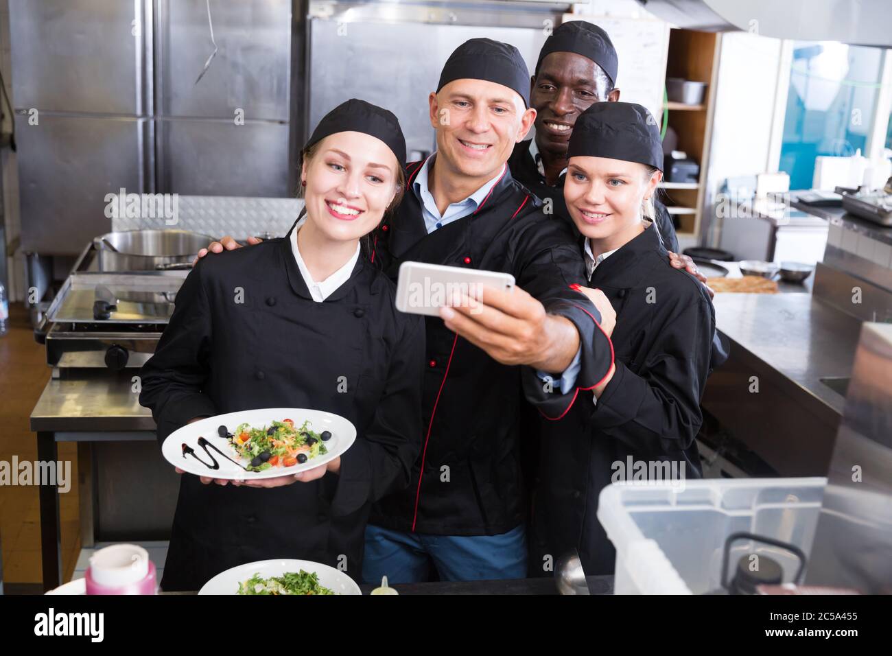 Happy multinational team of restaurant staff making selfie in ...