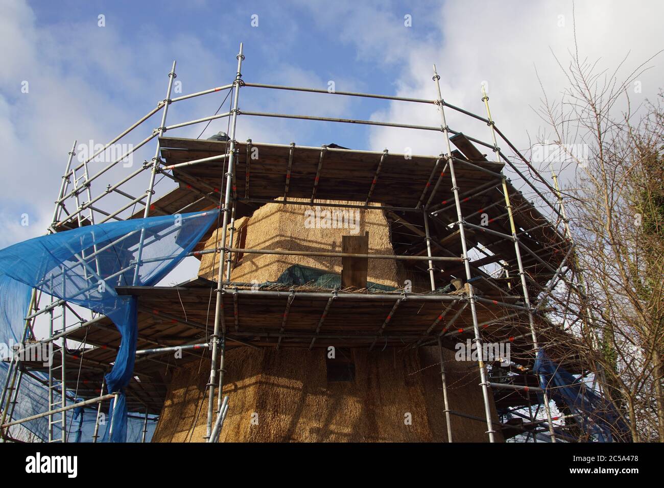 Old thatched windmill in the Netherlands. Being restored. Without hood ...