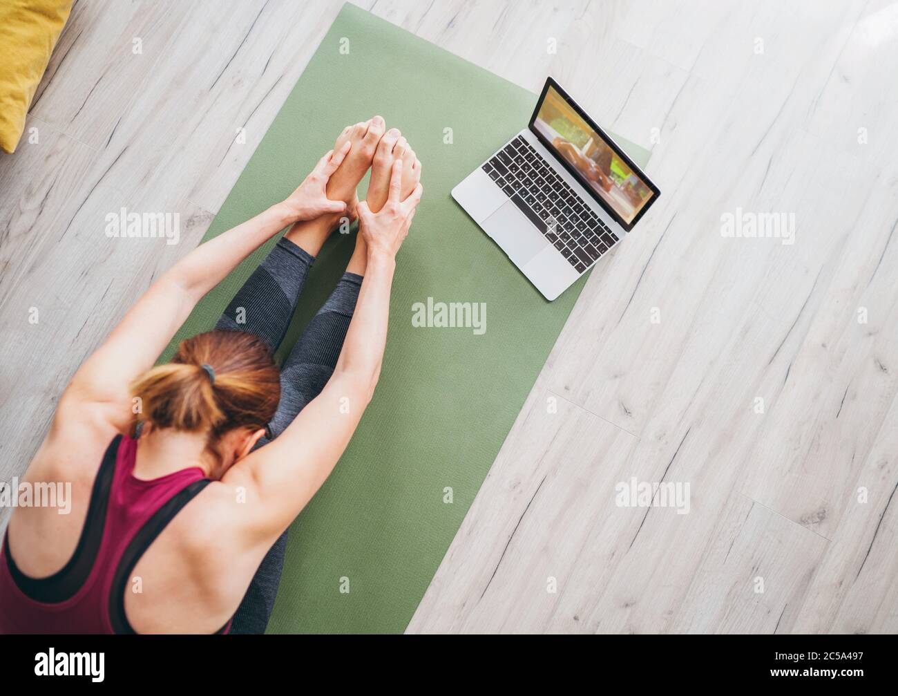 Fit sporty healthy woman sitting on mat in Paschimottanasana pose ...