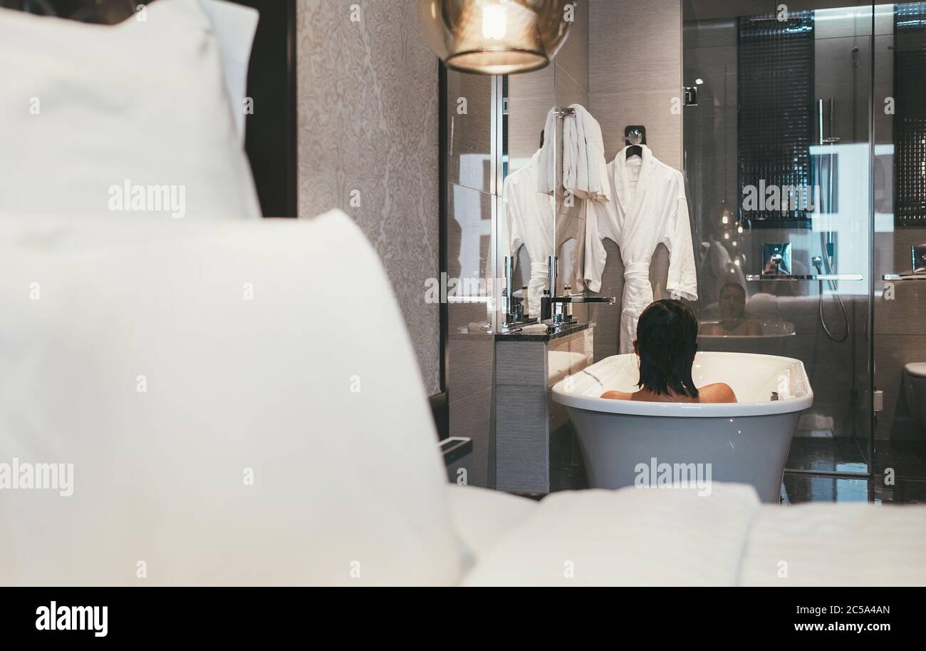 Woman traveler taking a bath in 5-star high-quality hotel bathroom. She ...