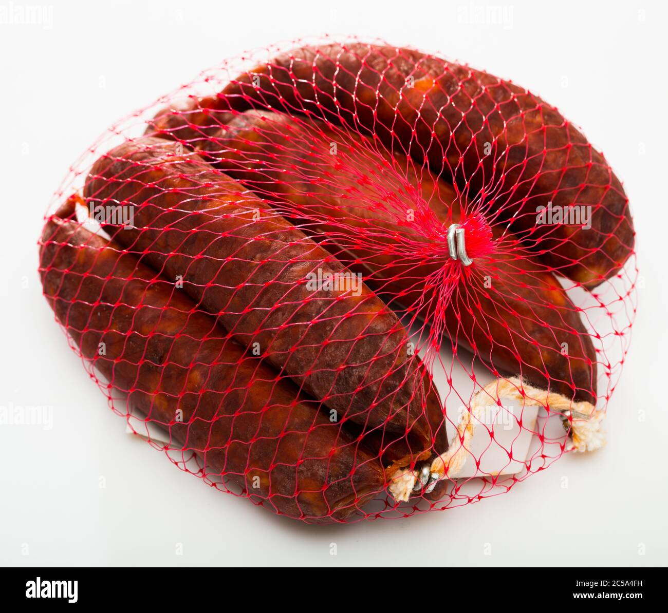 Spanish dry cured sausages chorizo in nylon packaging net on white ...