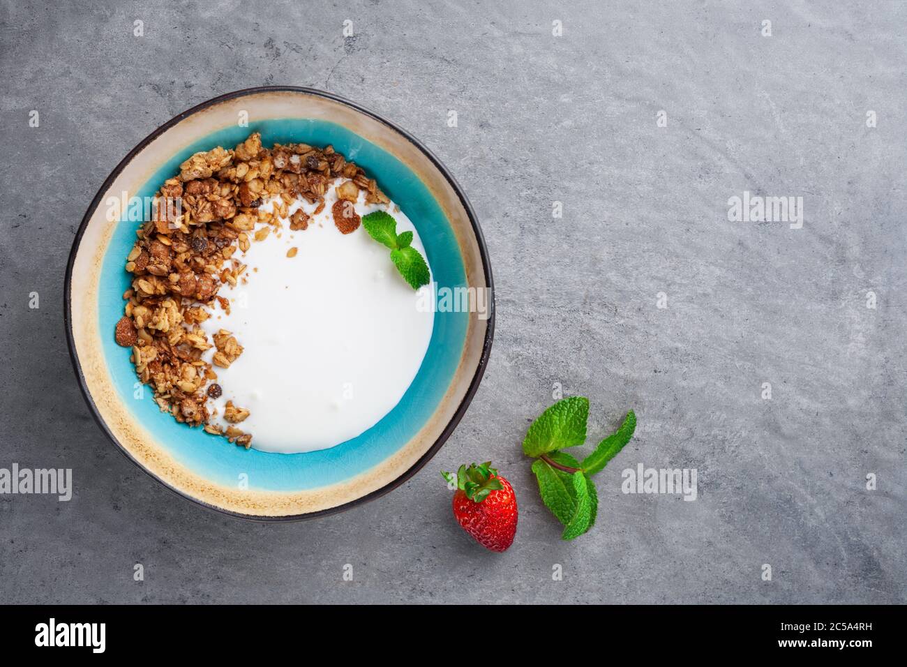 Portion of Natural yogurt with homemade cereal granola in blue bowl ...