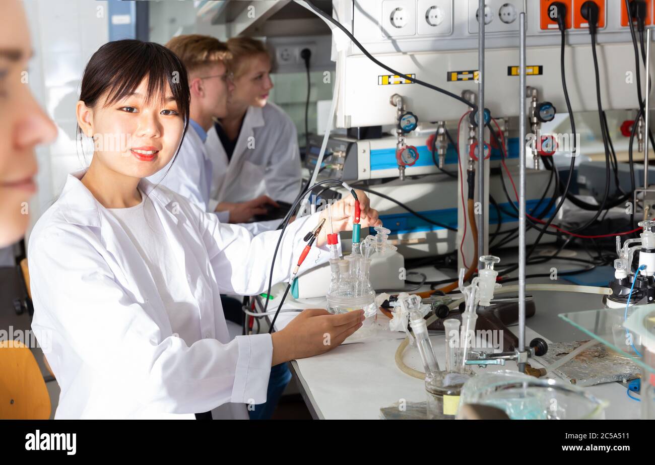 Serious Chinese female scientist near laboratory equipment at ...