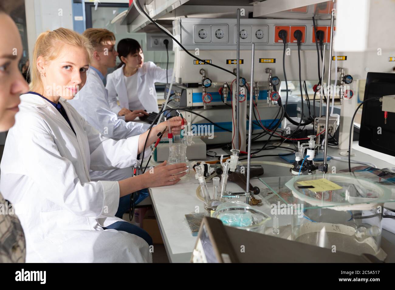 Portrait of young female lab technician engaged in research in chemical ...