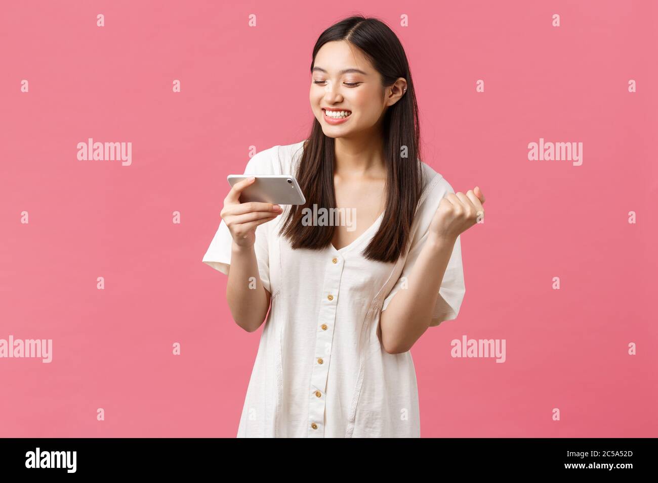 Beauty, people emotions and technology concept. Cheerful happy girl win ...