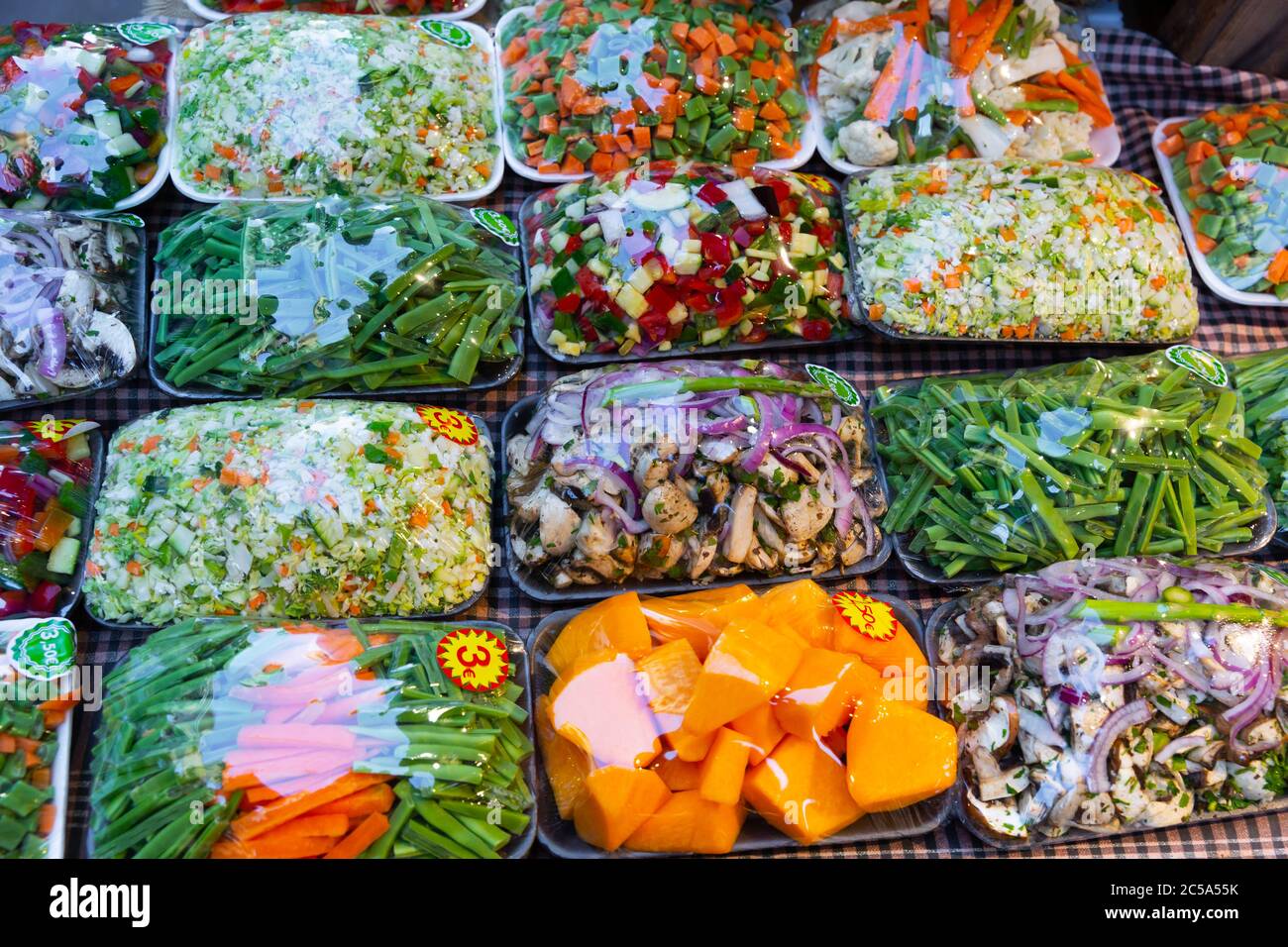 Sets of chopped vegetables wrapped in film on supermarket shelves Stock ...