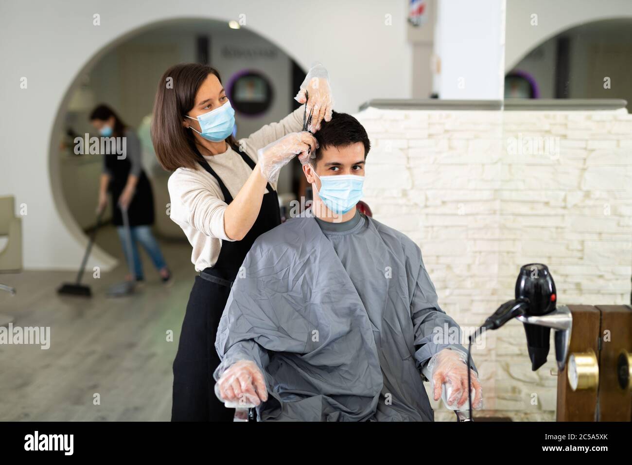 Man client in mask during hair cut by professional hairdresser in mask ...