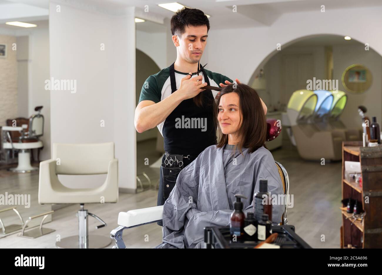 Girl client during hair cut by professional hairdresser at beauty salon ...