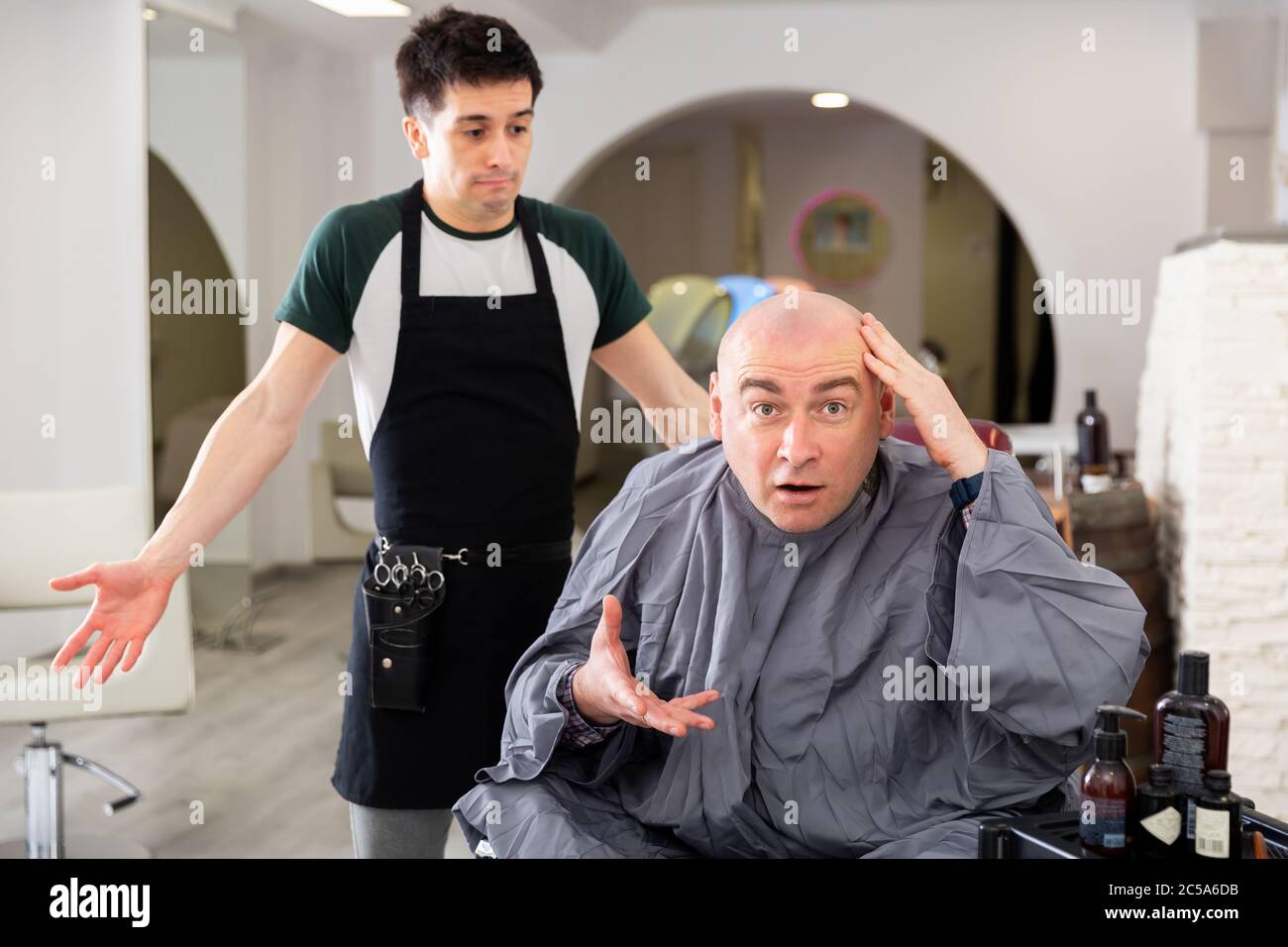 Portrait of angry man with shaved head shocked by haircut and ...
