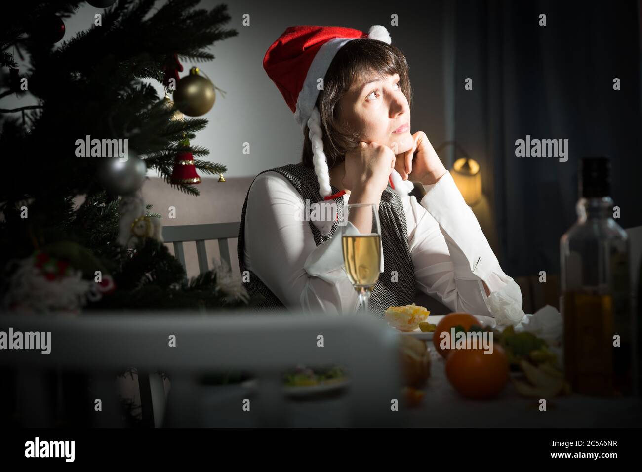 Sad bored adult woman watching Christmas tv program sitting alone at ...