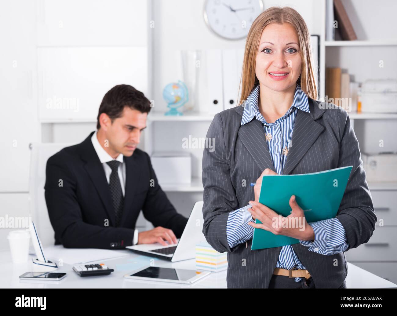 Elegant business woman writing down tasks with chief on background ...