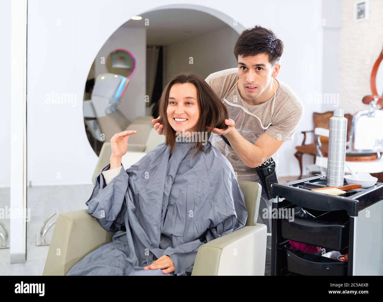 Happy cheerful positive smiling young woman and hairdresser after ...