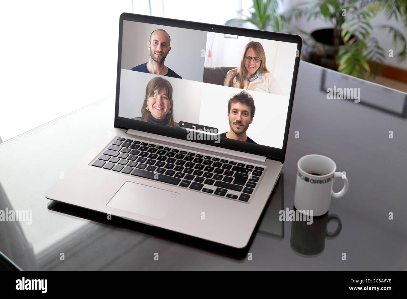 Laptop with video conference in screen. A group a young people having a ...