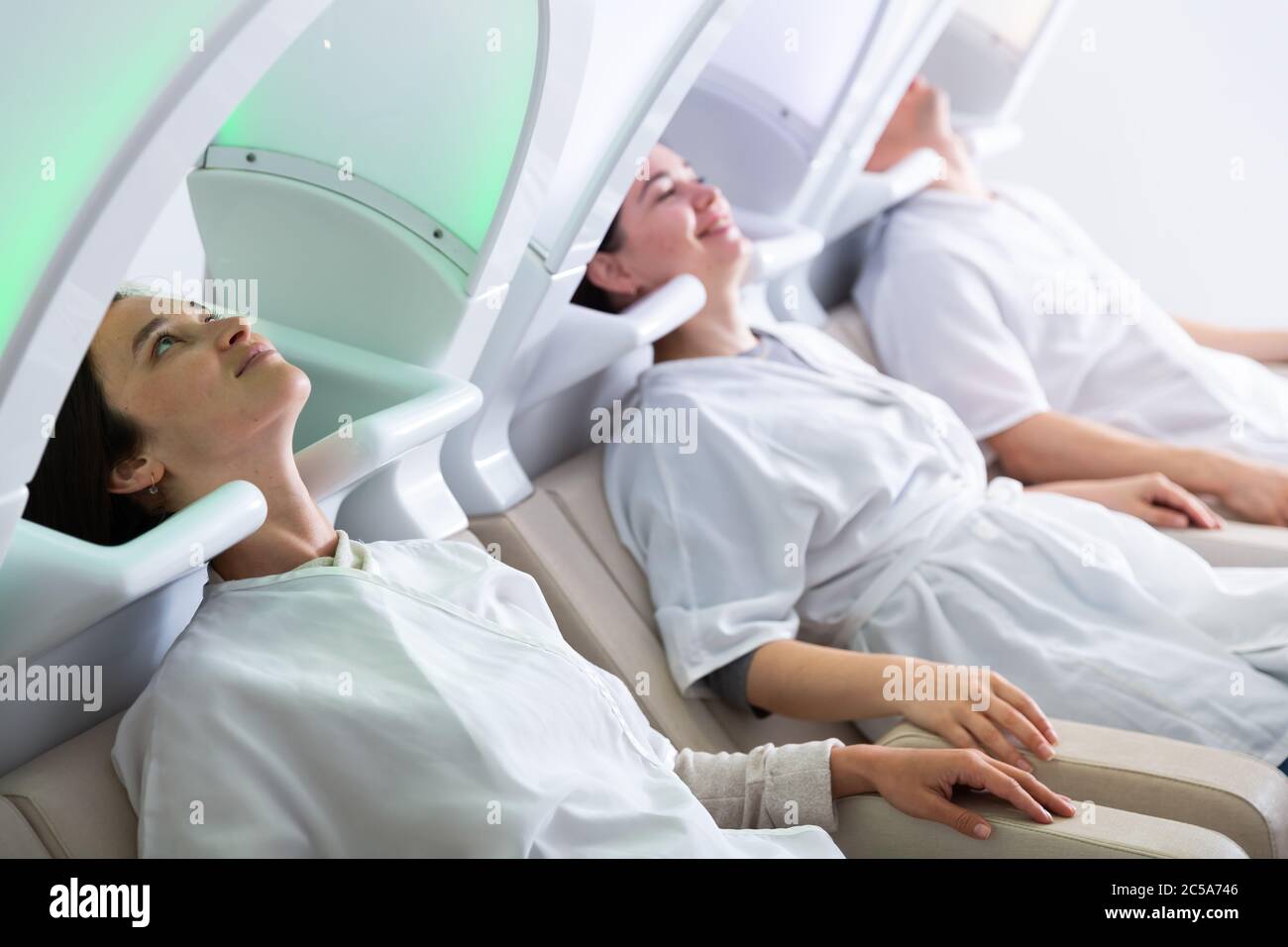Young people clients of beauty salon relaxing on massaging chairs Stock ...