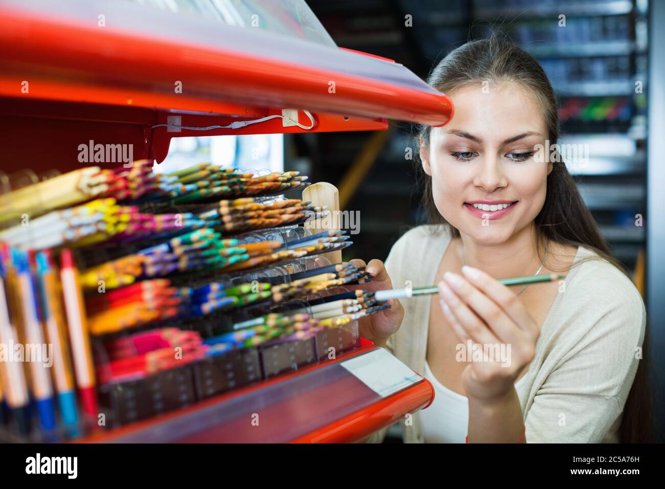 Portrait of glad cheerful woman choosing pencils for drawing in art ...