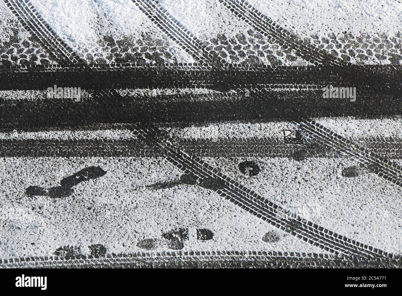 High angle shot of footprints and tire tracks on the snow Stock Photo ...
