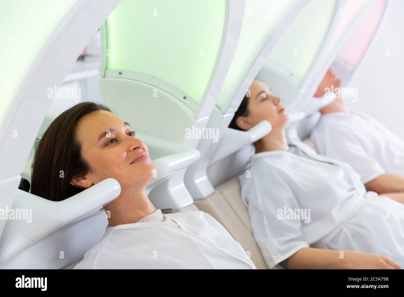 Young people clients of beauty salon relaxing on massaging chairs Stock ...