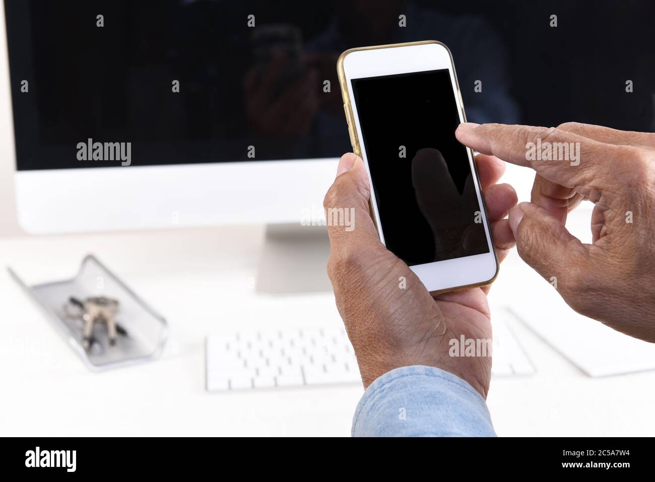 Work from Home Concept. Closeup of a man holding his cell phone in ...