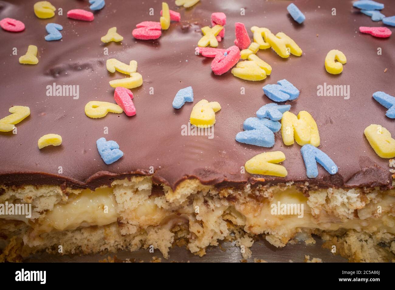 Homemade chocolate cake covered with glimmer sugar letters. Closeup ...