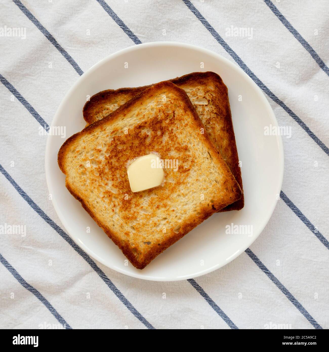Homemade Buttered Toast on a white plate, top view. Flat lay, overhead ...