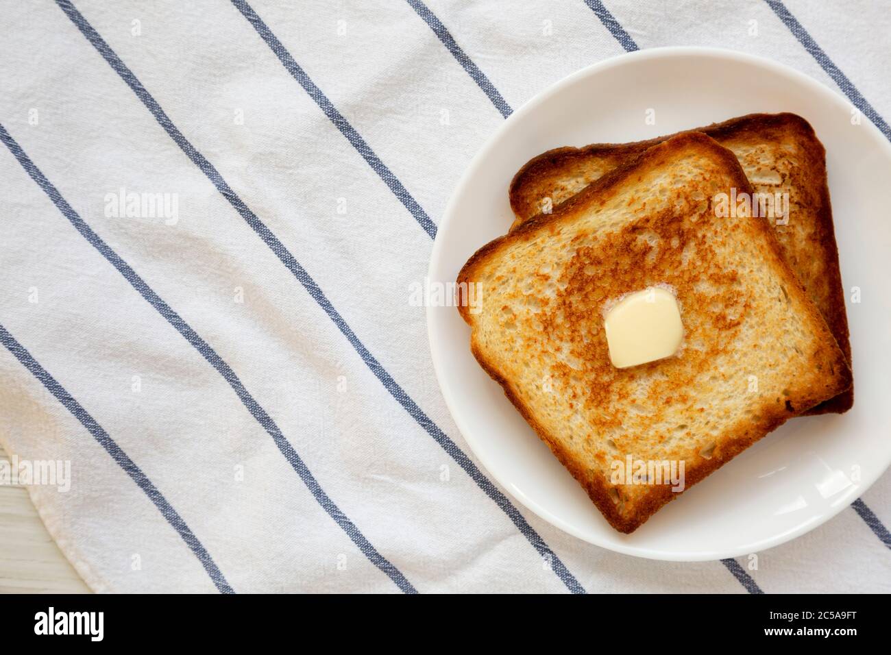 Homemade Buttered Toast on a white plate, top view. Overhead, flat lay ...