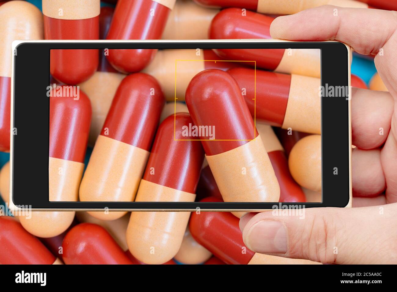 Medication capsules on smartphone screen. Pharmaceutical drug is ...