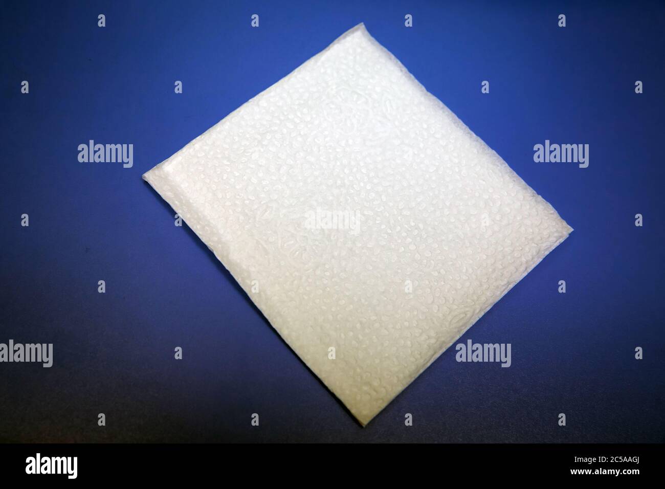 Blank paper napkin isolated on blue background with copy space . White ...