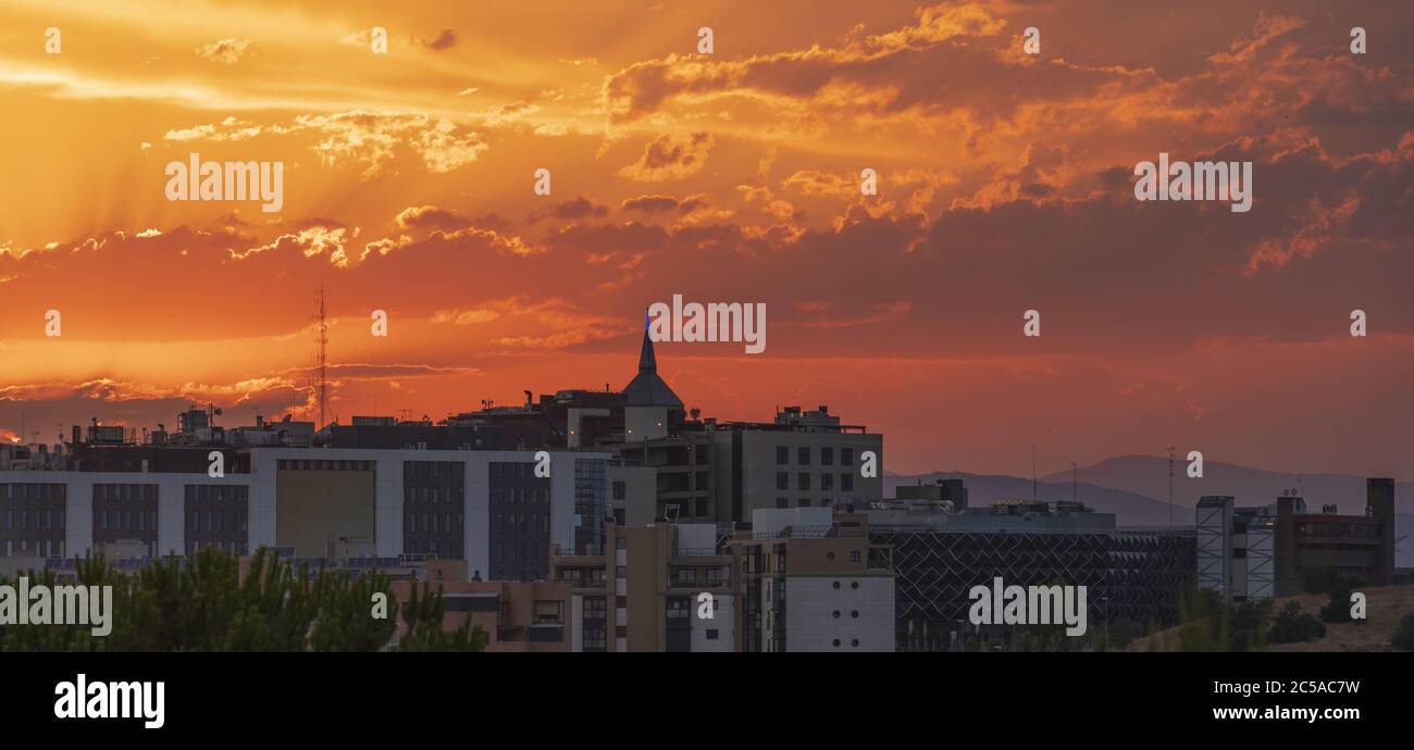 Breathtaking view of golden sunset sky with clouds over city buildings ...