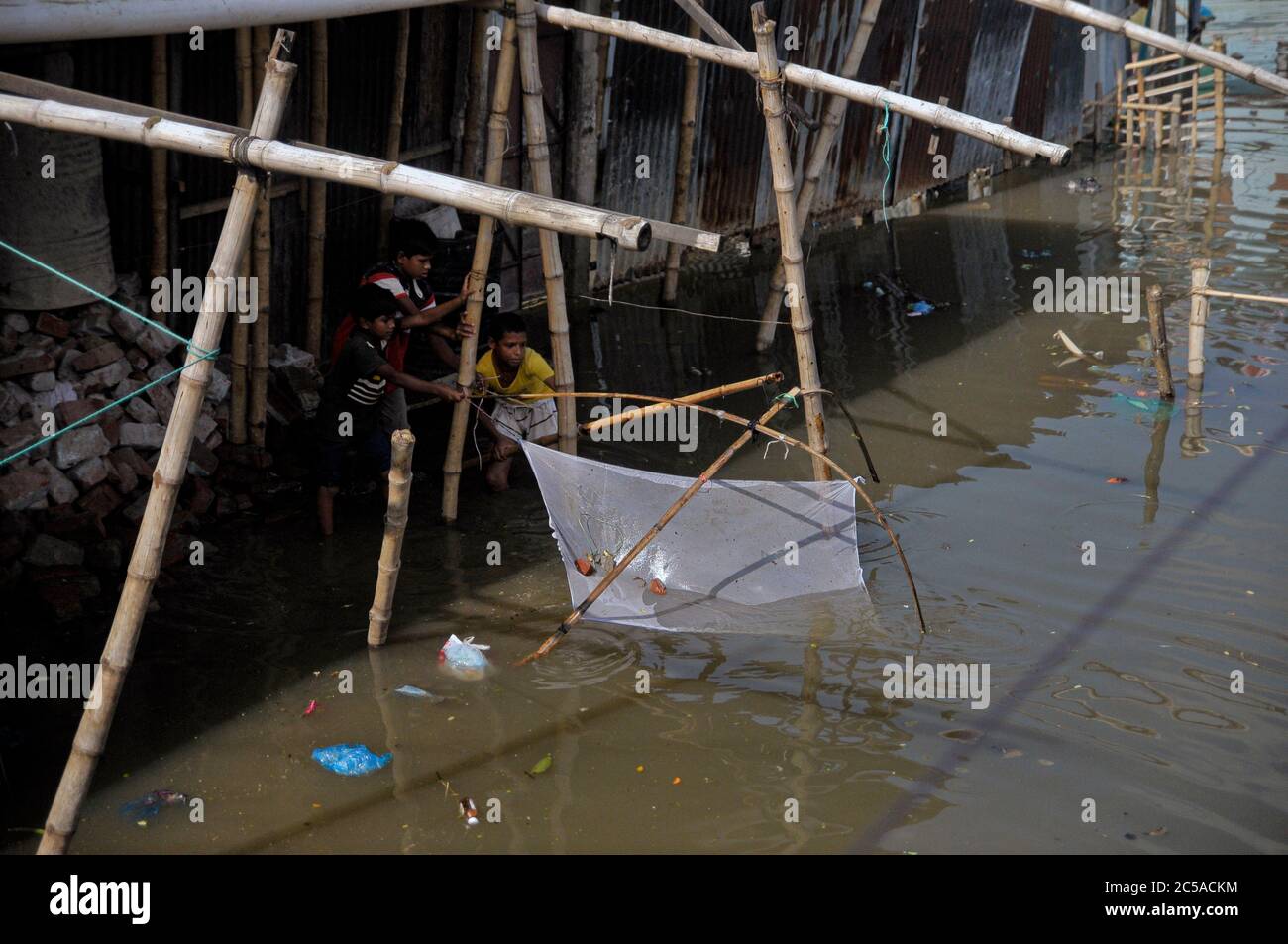Kids catching fish in flood water at a slum in kamalgor. Nearly 2.5 ...