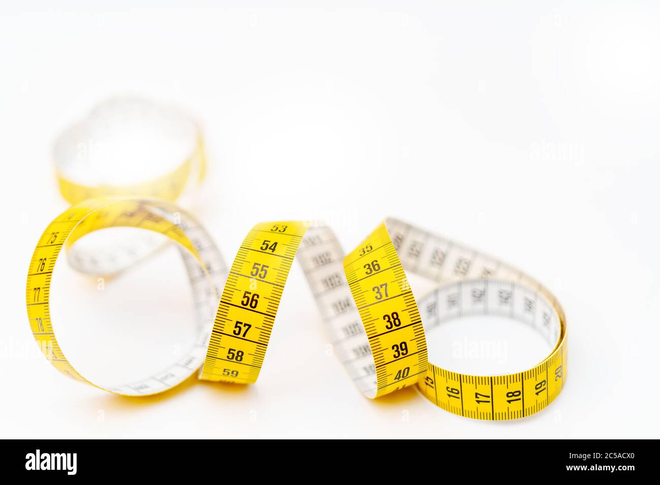 Yellow measuring tape on white background. Measurement of length and ...