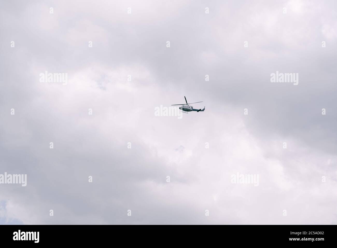 Passenger helicopter flies in the sky among the clouds Stock Photo - Alamy