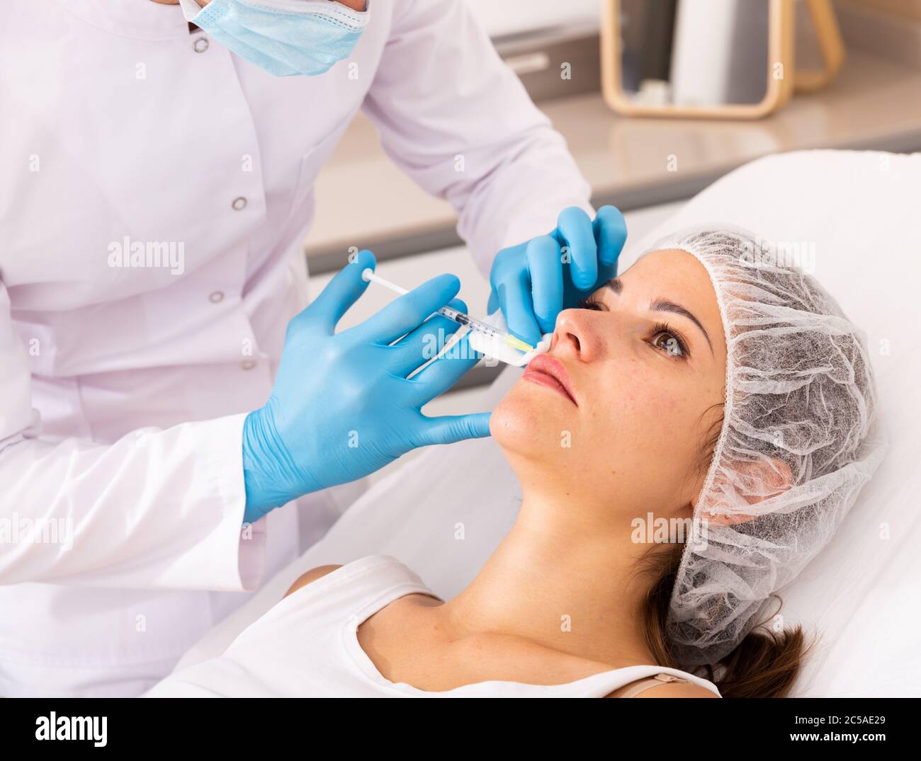 Young woman getting procedure of injection contouring for facial ...