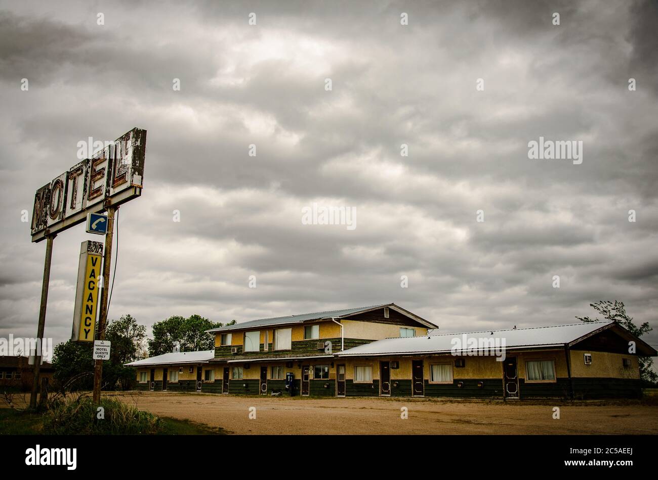 Rusty metal motel sign with wooden old motels under the cloudy and ...