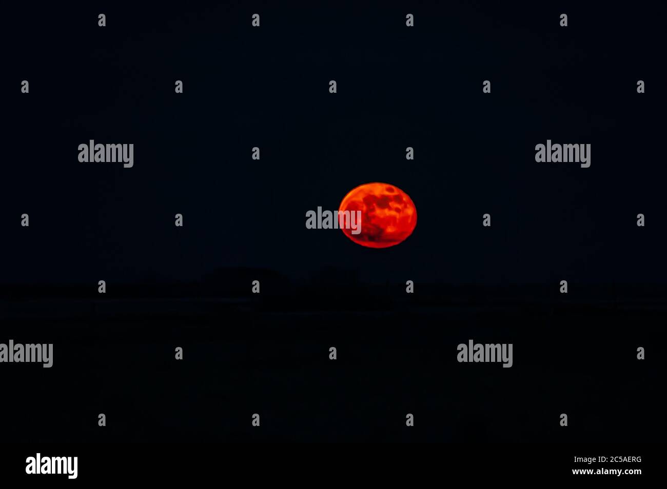 Breathtaking view of the fascinating blood-red moon shining in the dark ...