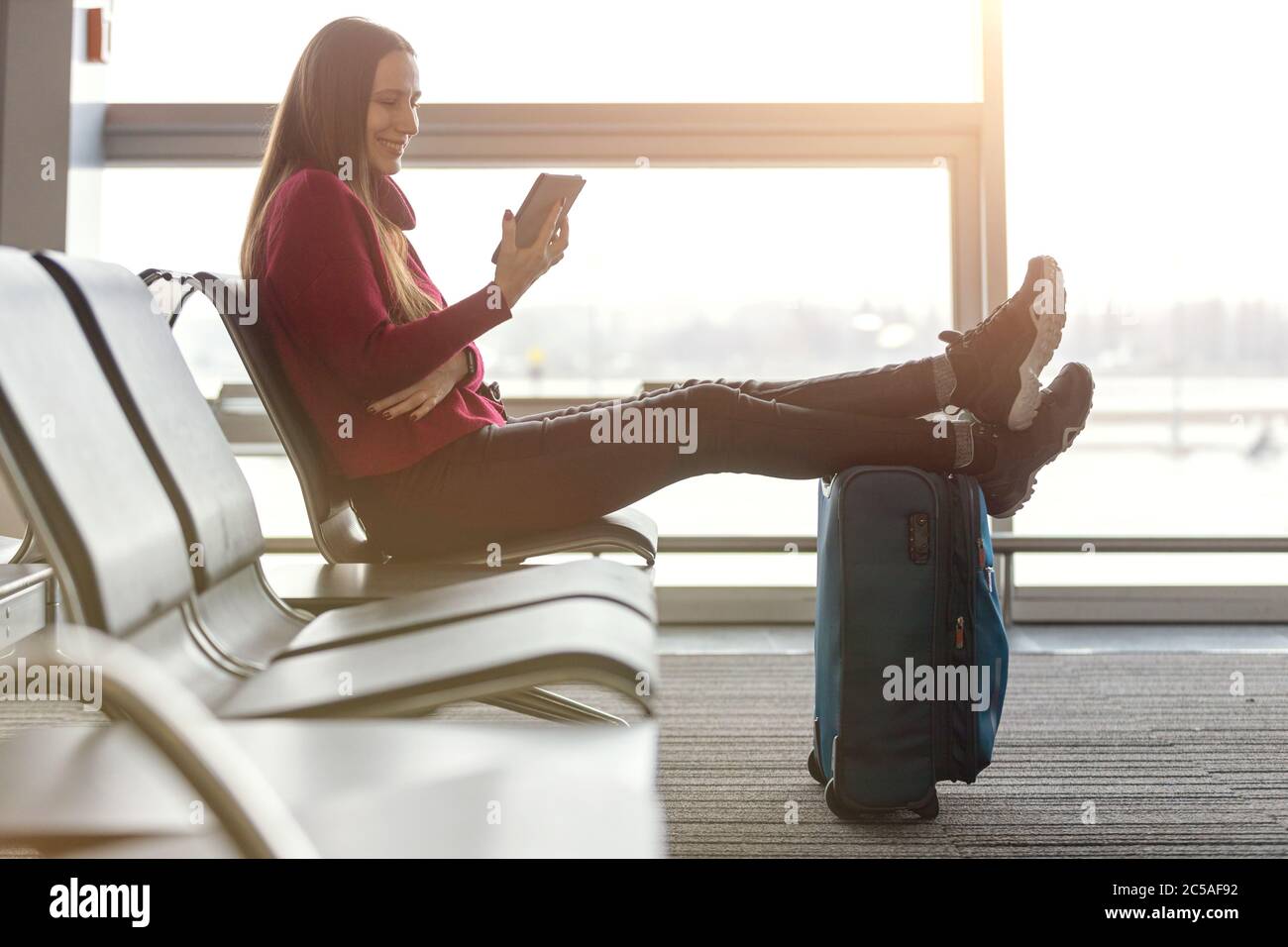 Young woman reading book waiting for the flight at the airport Stock ...