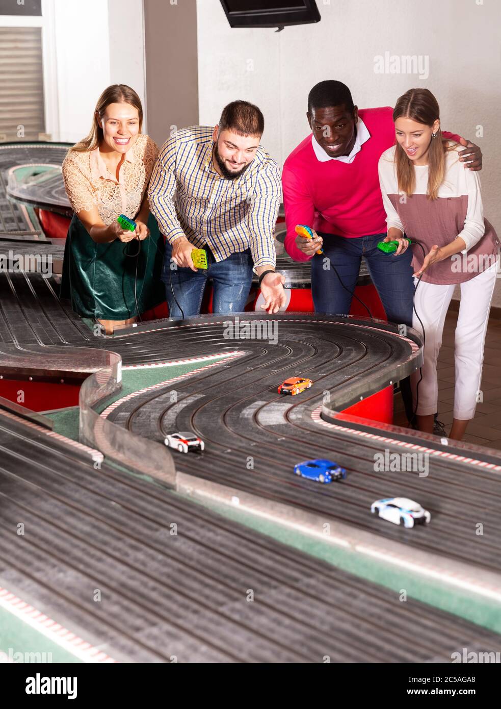 Portrait of passionate adult friends playing car models Stock Photo - Alamy
