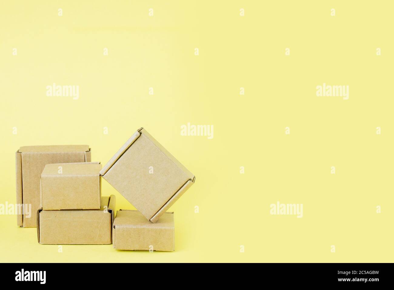 Cardboard boxes of various sizes on yellow background Stock Photo - Alamy