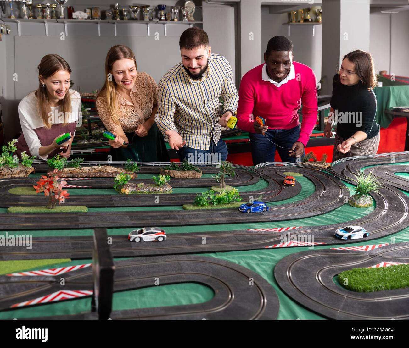 People playing with slot car racing activity Stock Photo - Alamy
