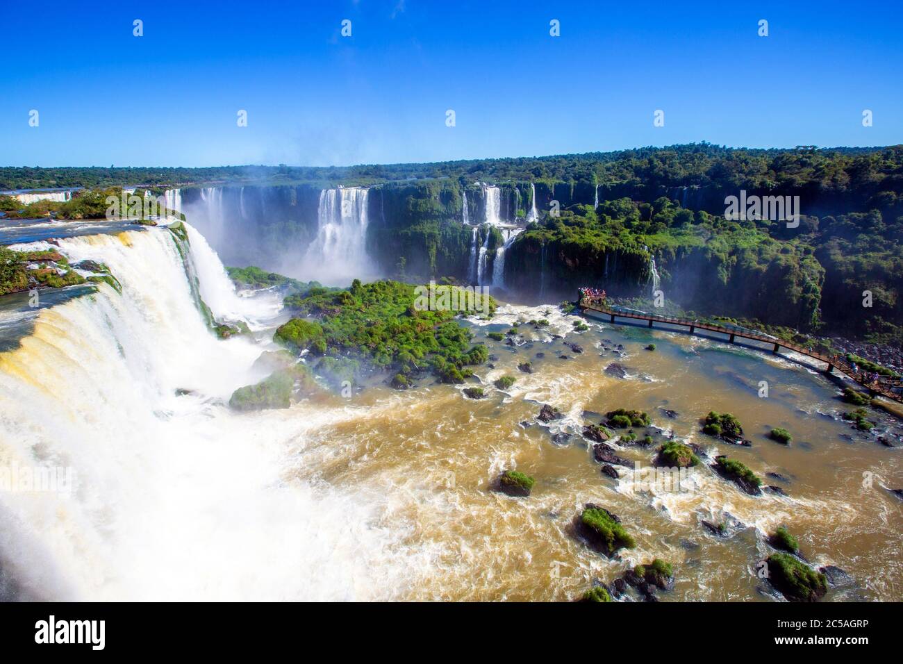 Iguazu Falls in Brazil surrounded by trees under the blue sky Stock ...