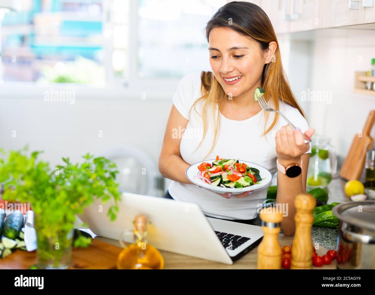 Nice latino woman planning to cook, looking for recipe on internet in ...