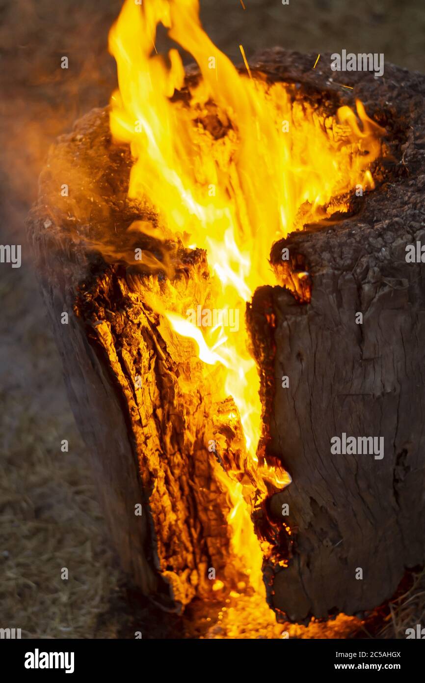 Vertical image of a burning log creating a fiery background Stock Photo ...
