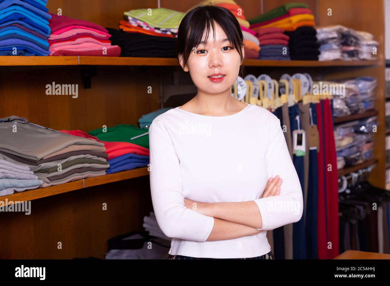 Chinese female shopping assistant offering various shirt in men’s ...