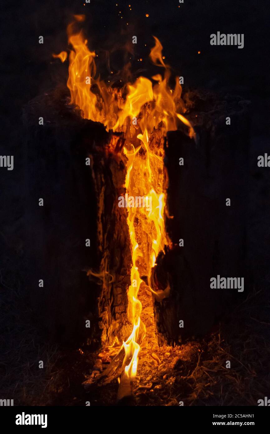 Vertical image of a burning log creating a fiery background Stock Photo ...