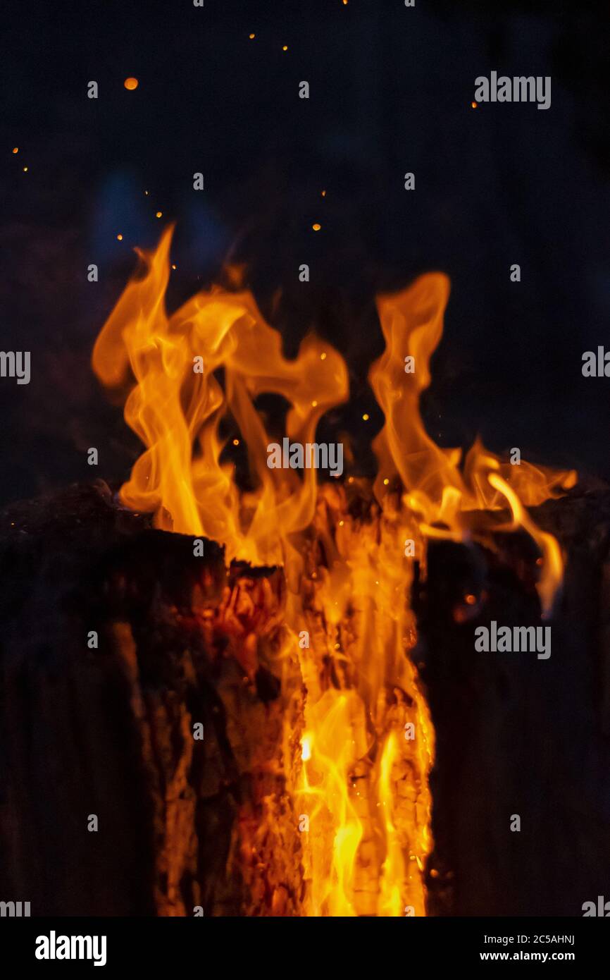 Vertical image of a burning log creating a fiery background Stock Photo ...