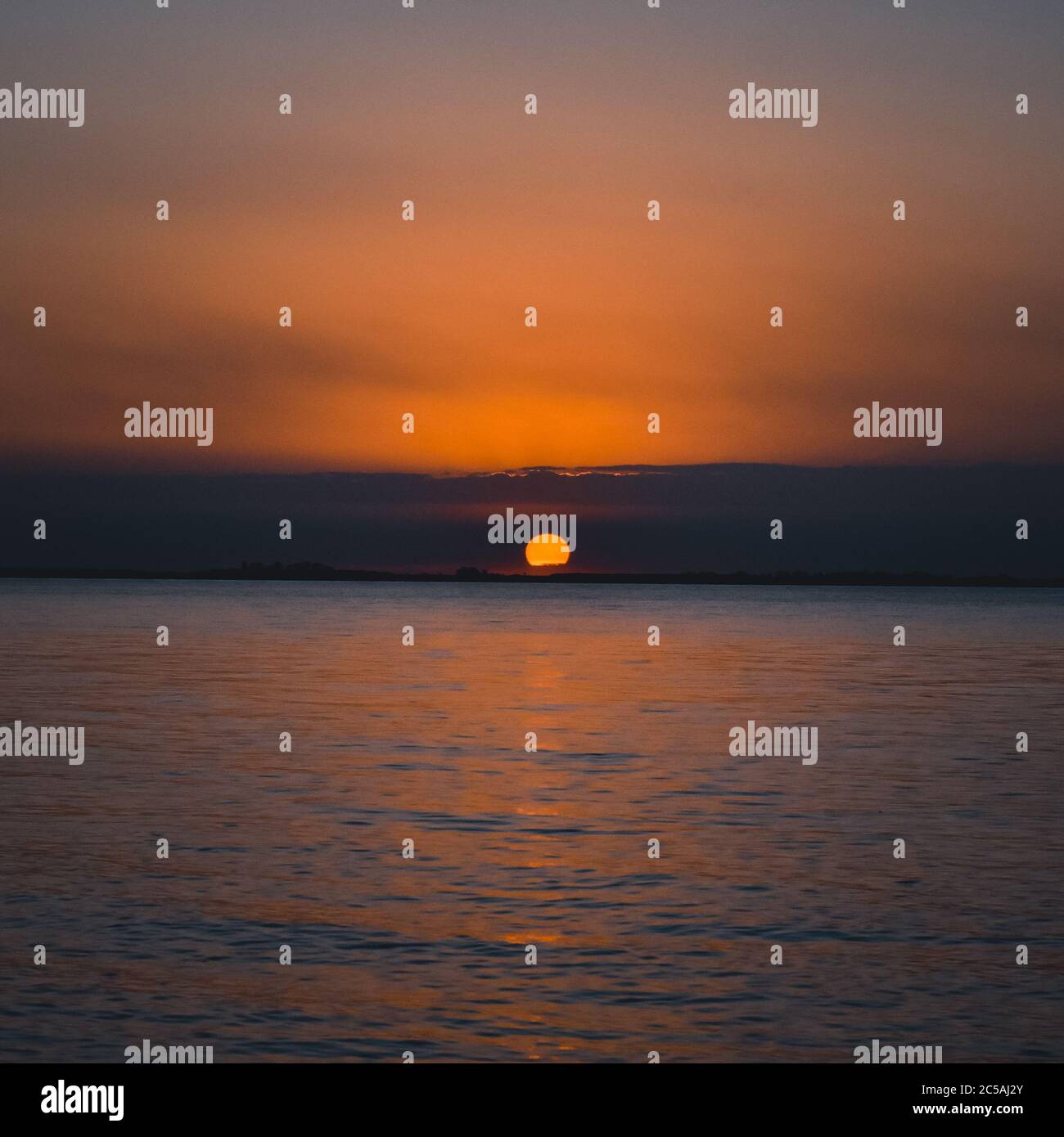 Beautiful setting sun on the beach Stock Photo - Alamy