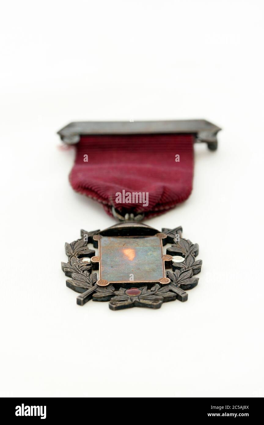 Wreath shaped medal with maroon ribbon Stock Photo - Alamy