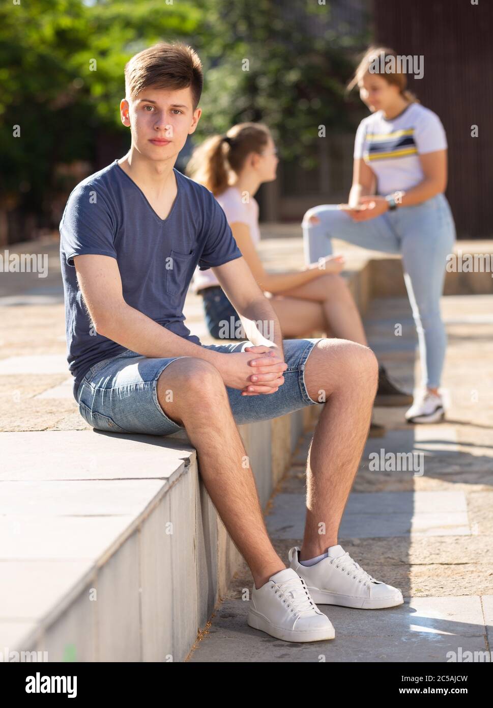 Portrait of guy against the background of his friends in spring park ...