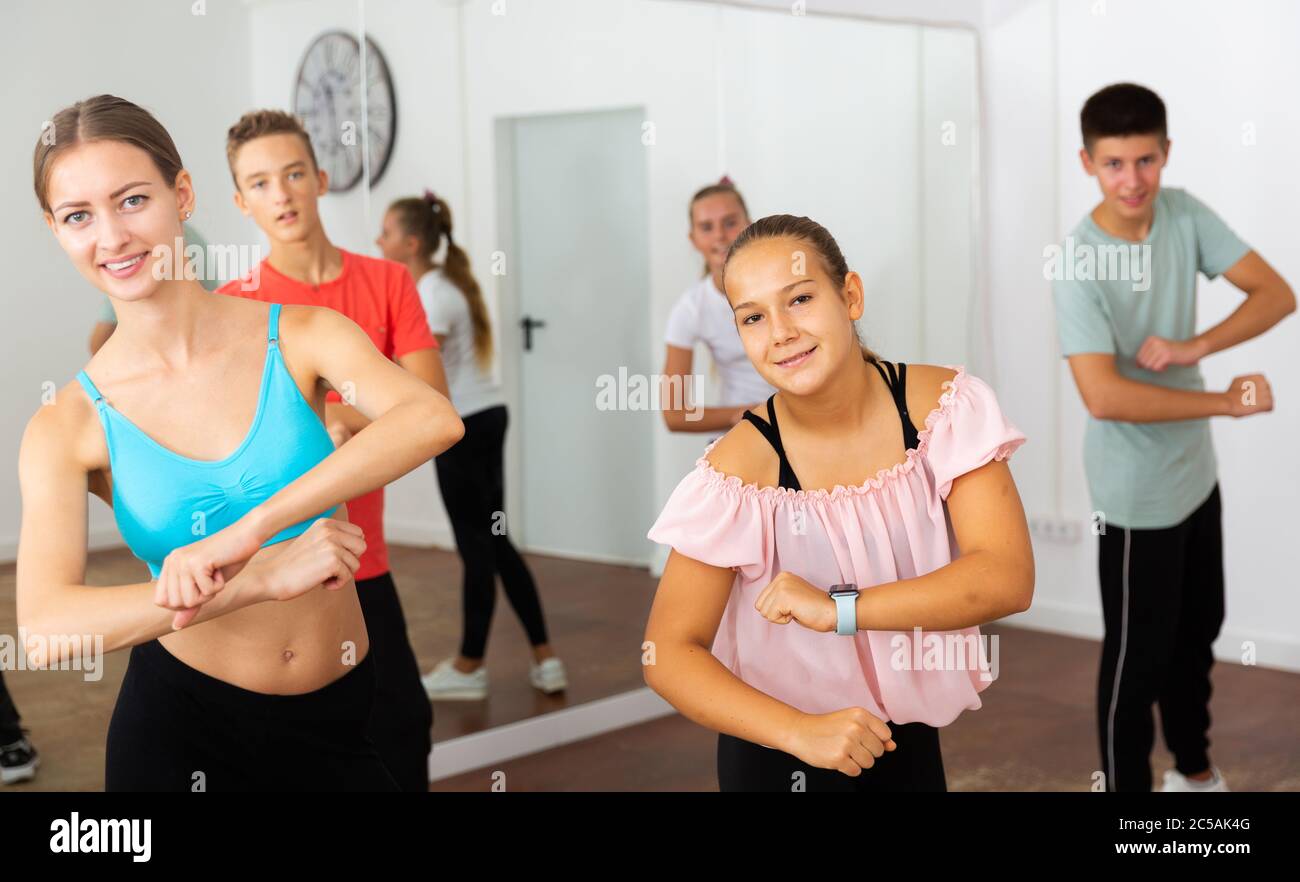 Group of teenagers participating in dance class, following their young ...
