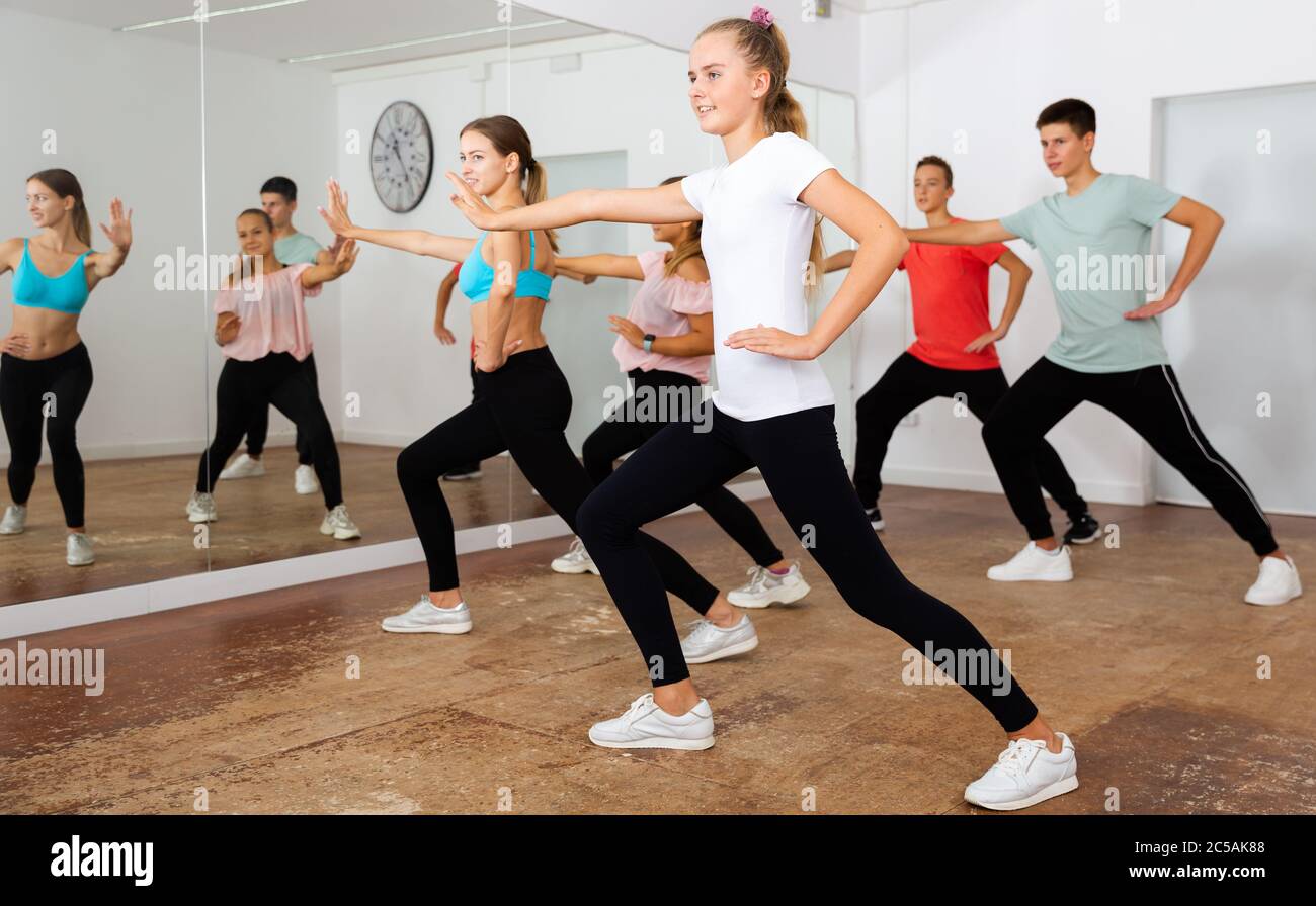 Group of teenagers participating in dance class, following their young ...